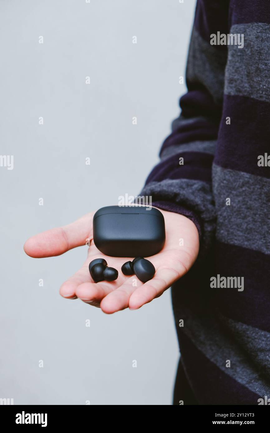 Man Holding Black Wireless Earbuds And A Case On A White Background ...