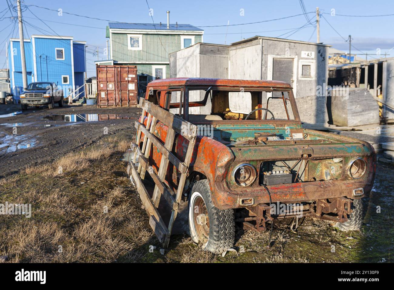 Scrapped car, off-road vehicle in front of simple houses, Arctic, Inuit ...
