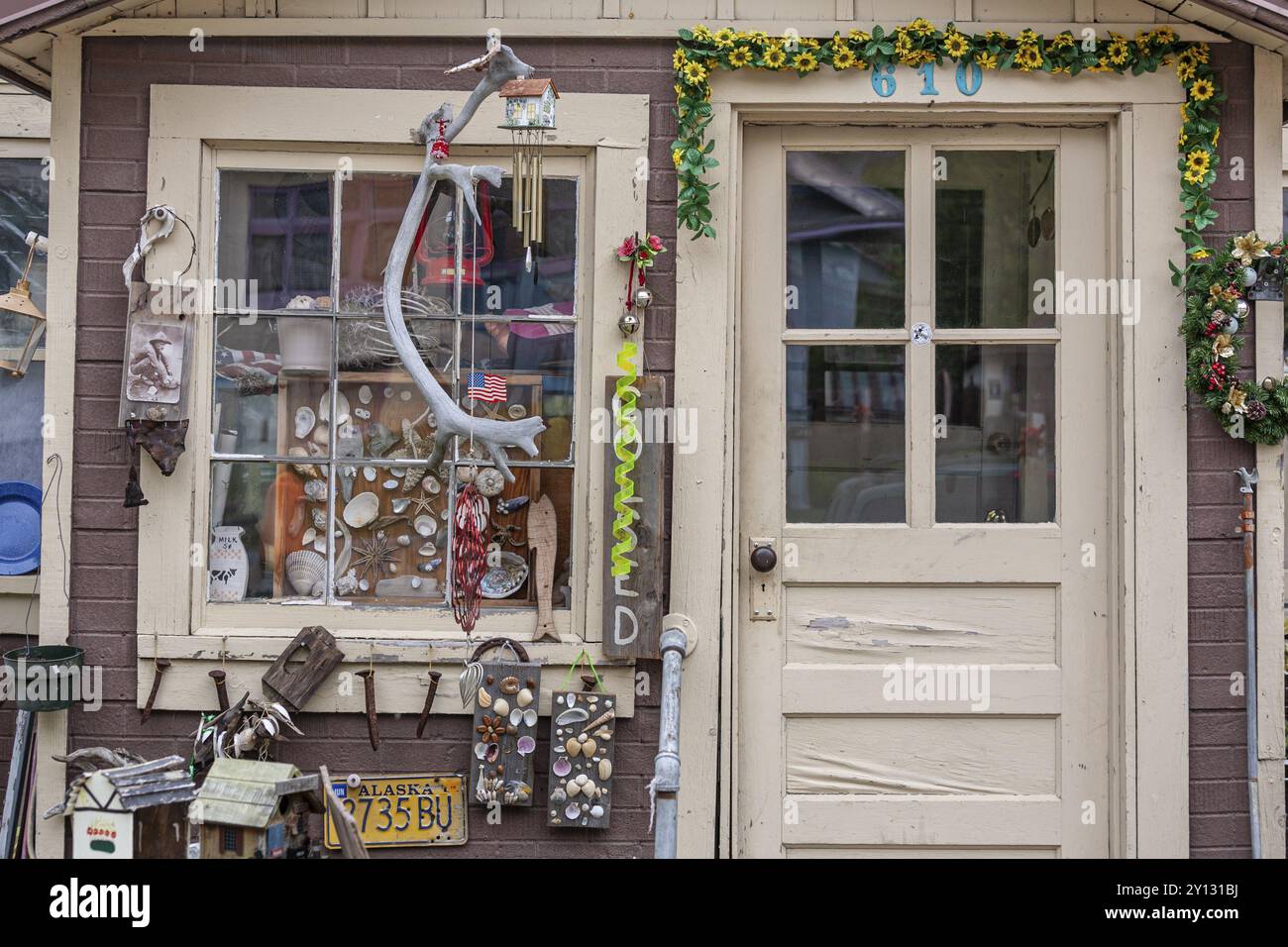 Art collection and crafts in front of a wooden house, shells, buoys ...