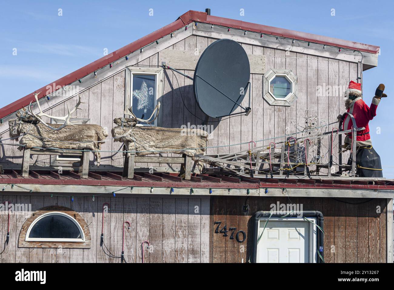 Santa Claus, Father Christmas on the roof of a simple wooden house ...
