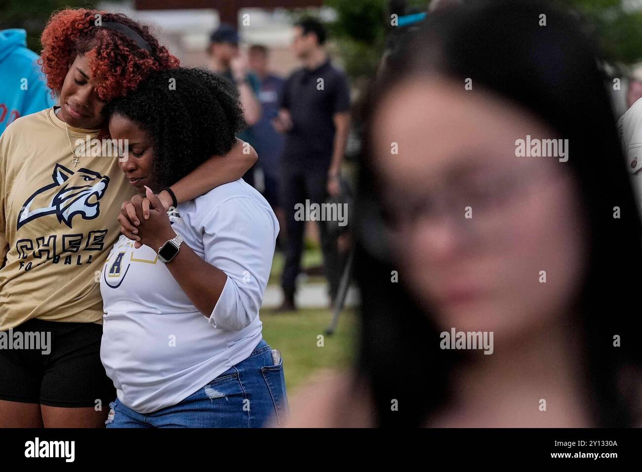 Mourners pray during a candlelight vigil for the slain students and ...