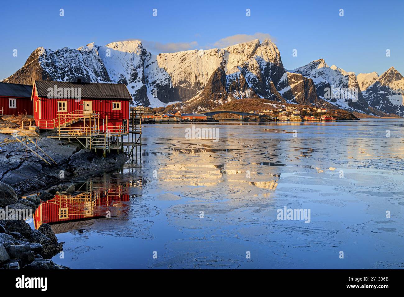 Typical Norwegian red house, fjord with ice floes in front of steep ...