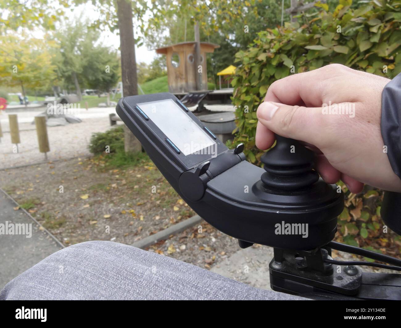 Close up of a disabled person hand driving electric wheelchair using ...