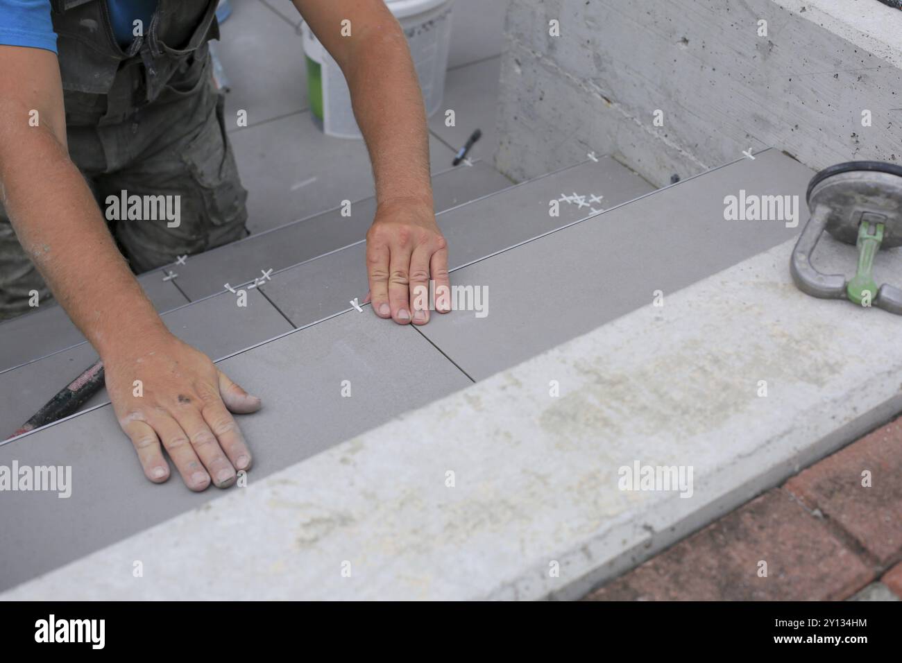 Tiler hands working on a new house entrance, local and professional ...