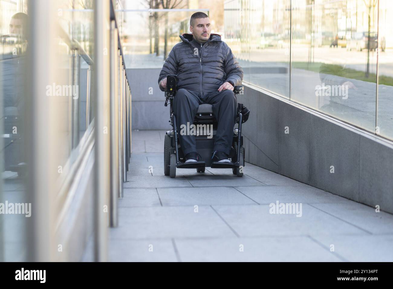 Man in a wheelchair using a ramp next to stairs Stock Photo - Alamy