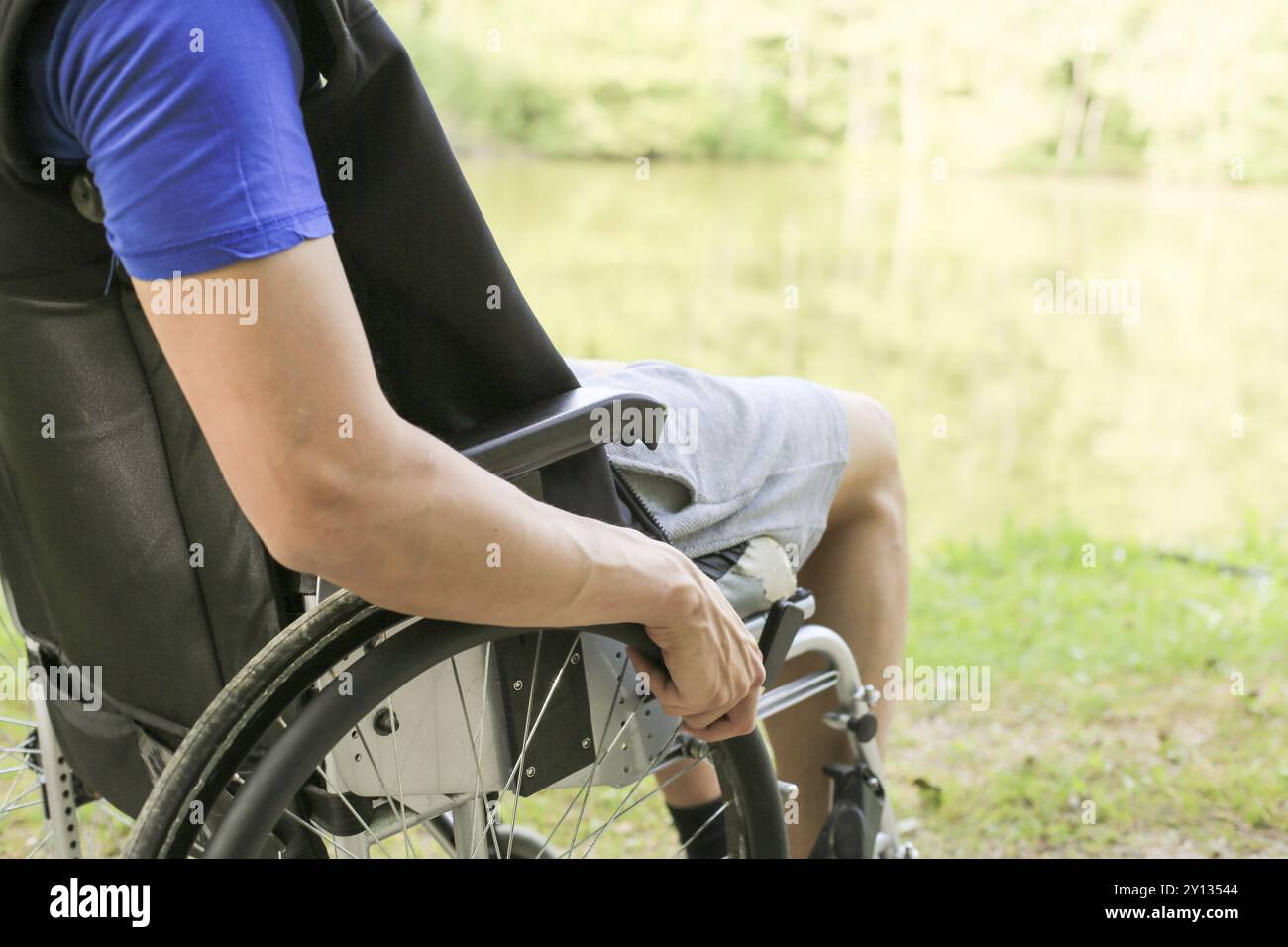 Young disabled or handicapped man sitting on a wheelchair in nature ...