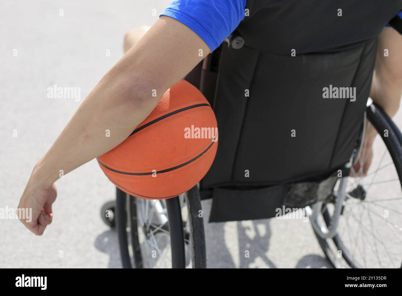 Disabled young basketball player on a wheelchair holding ball and ...
