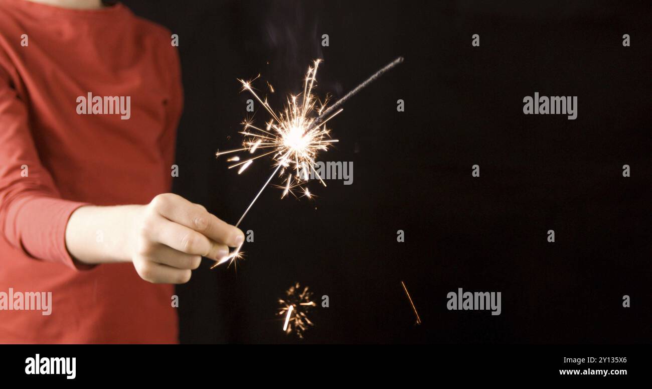 Child holding burning firework sparkler, celebrating Christmas and new ...