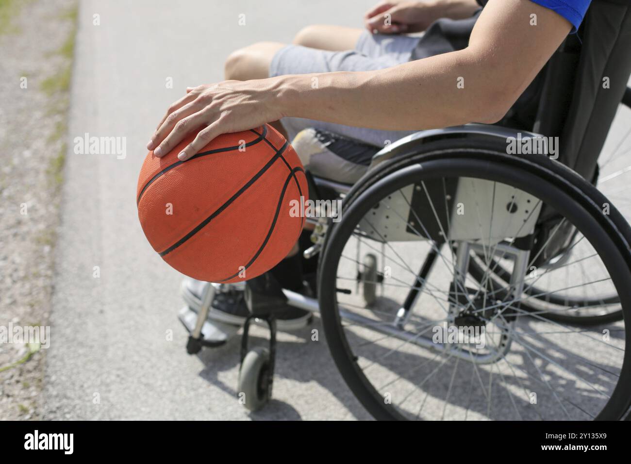 Disabled young basketball player on a wheelchair holding ball and ...