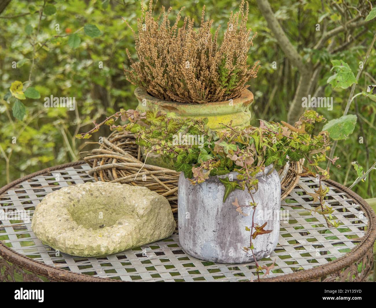 Colourful plant pots and a stone sculpture are placed on a grid-like ...