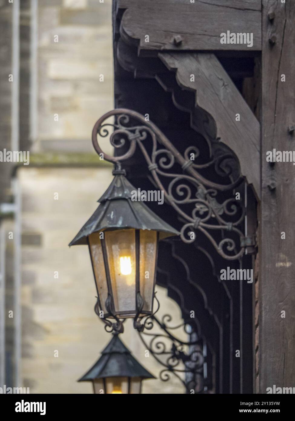 Antique metal street lamps hanging from a historic building, billerbeck ...