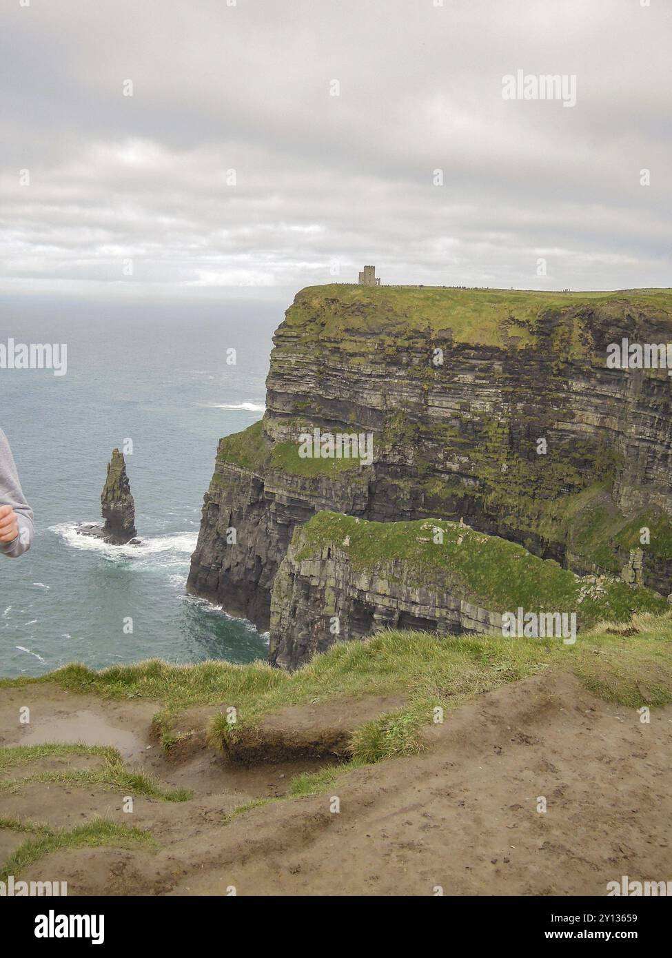 The imposing cliffs with a small tower at the top and lush greenery ...