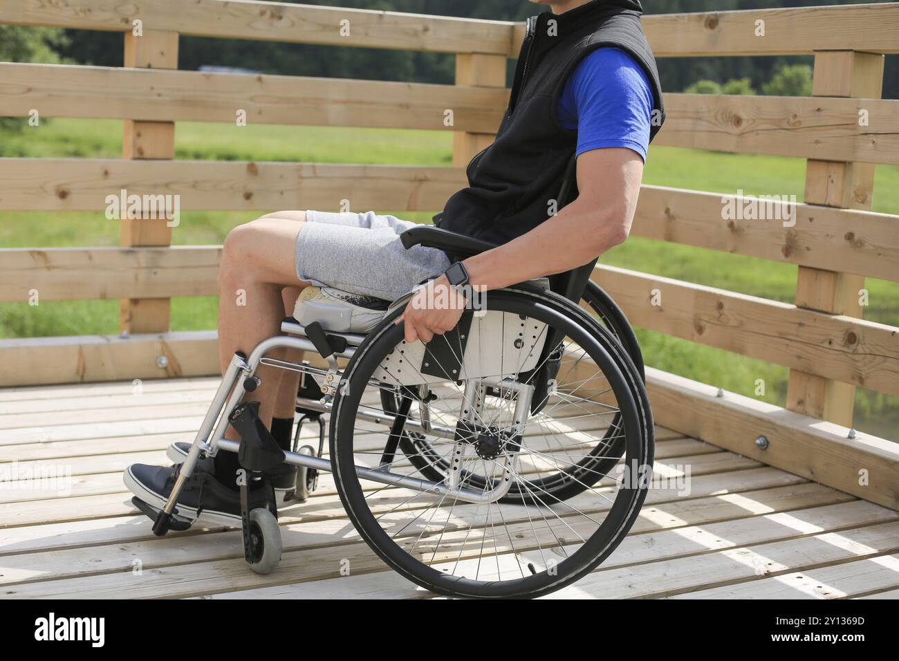 Disabled young man on a wheelchair holding and turning wheels with hand ...