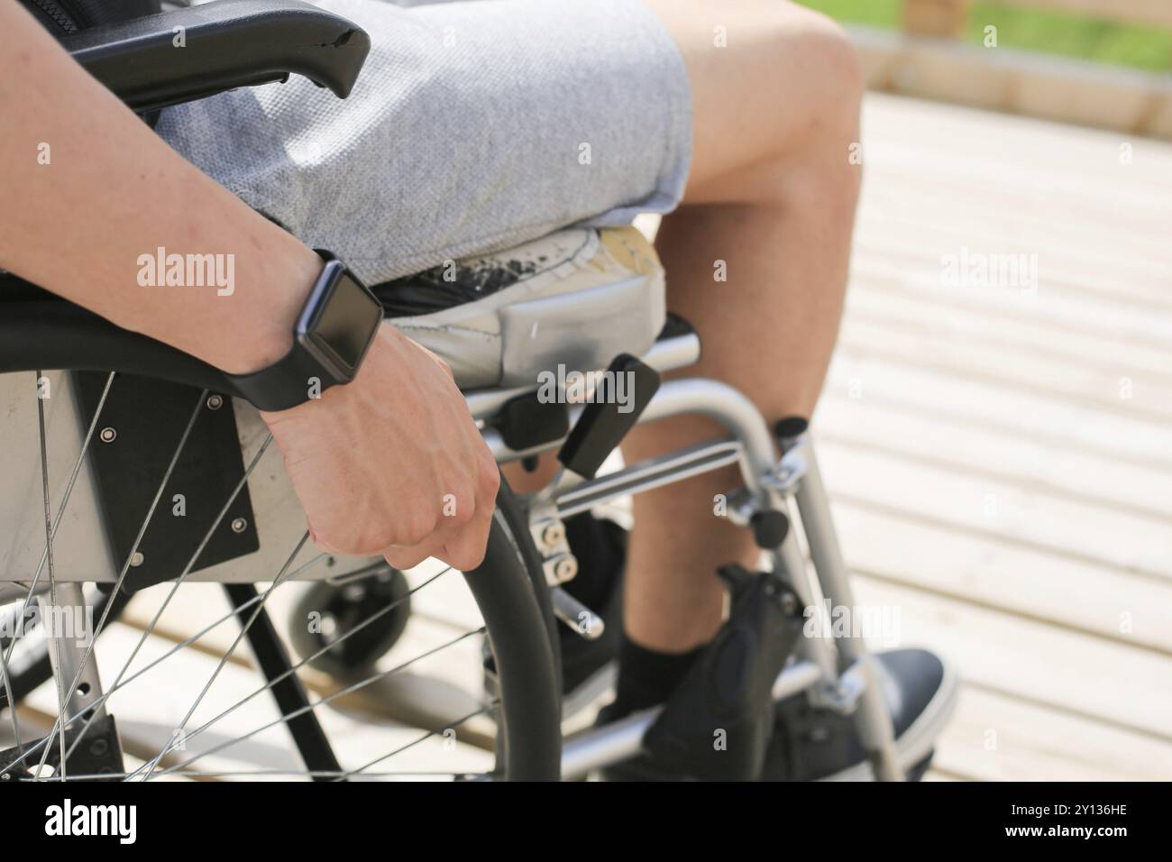 Disabled young athletic man on a wheelchair holding and turning wheels ...
