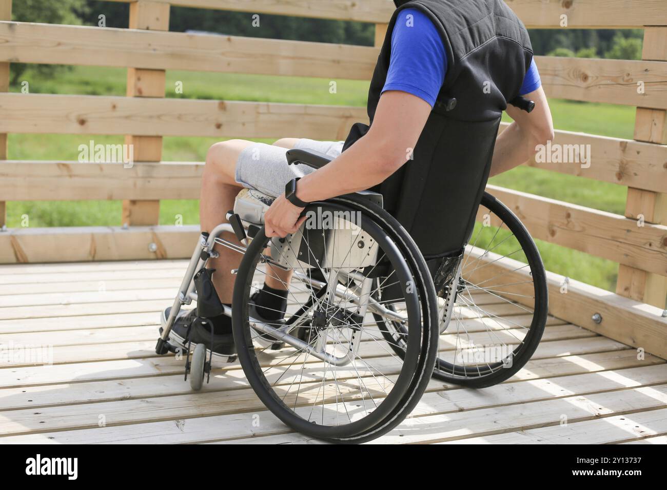 Disabled young man on a wheelchair holding and turning wheels with hand ...