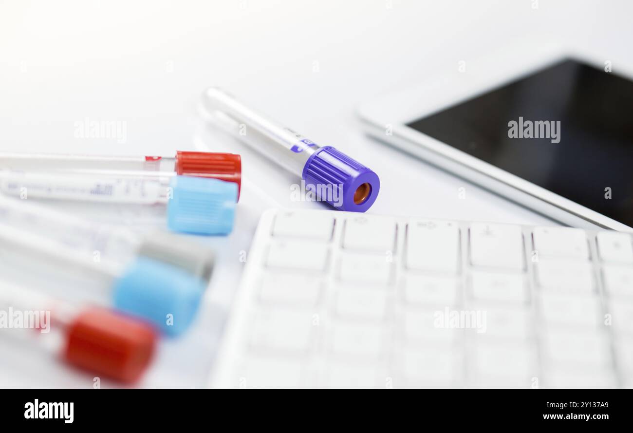 Close up photo of medicine bottles for samples next to computer tablet ...