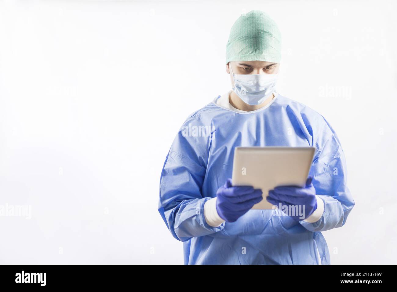 Surgeon doctor in sterile gloves preparing for operation using tablet ...
