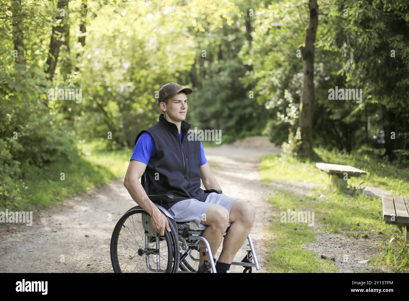 Happy and young disabled or handicapped man sitting on a wheelchair in ...