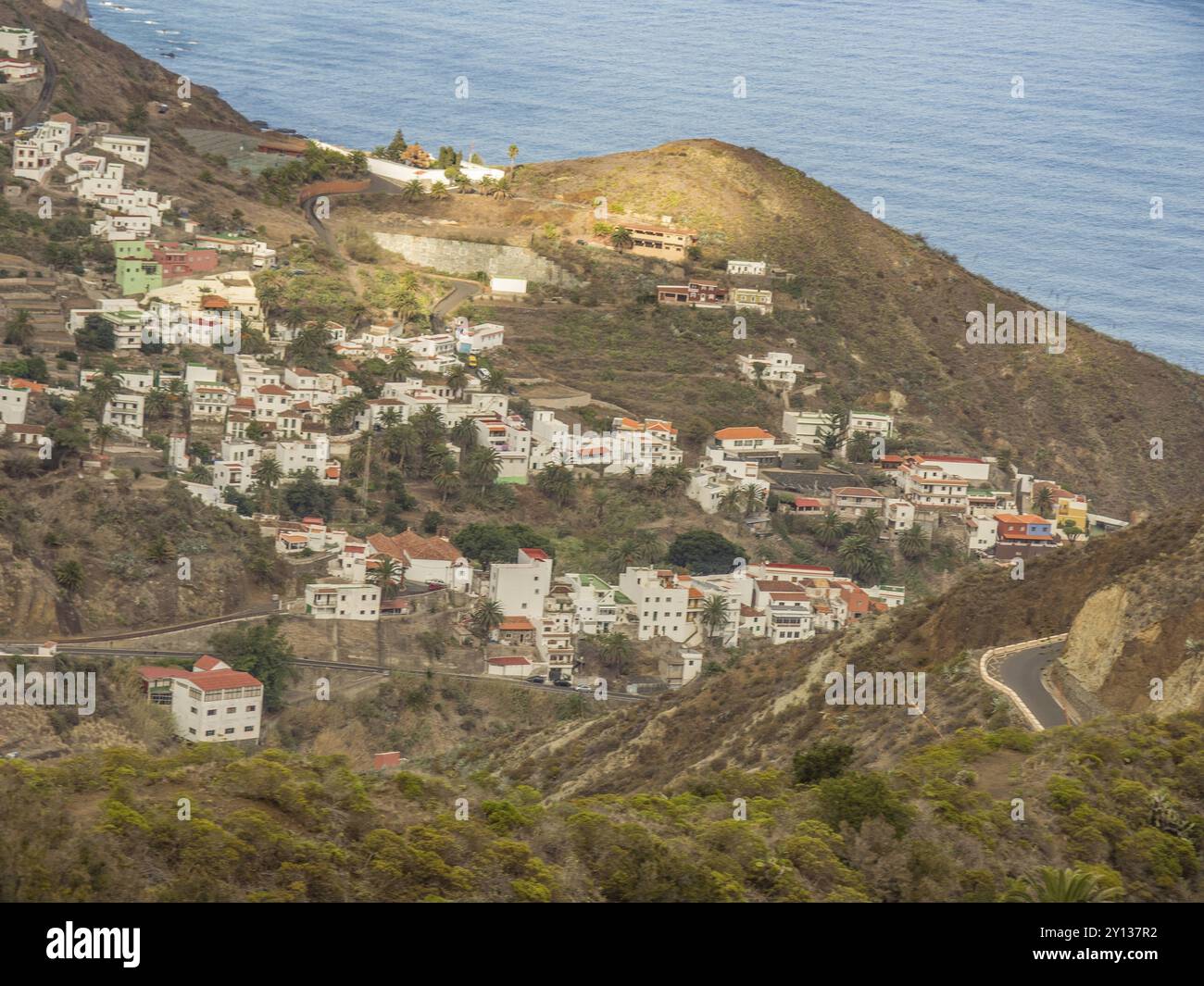 Mountain village on the coast with winding roads and scattered houses ...