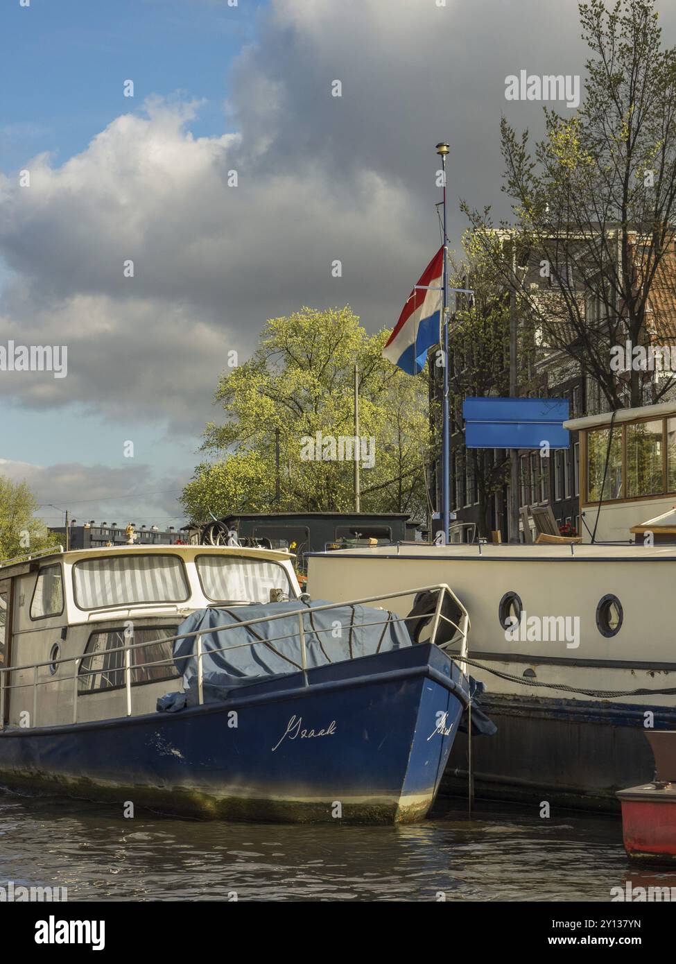 Boat on a canal with a Dutch flag, historical buildings in the ...