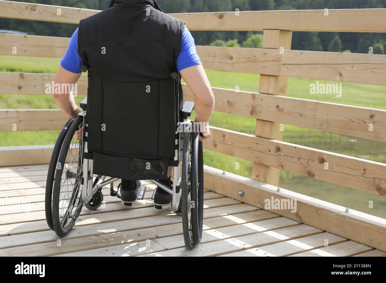 Disabled young man on a wheelchair holding and turning wheels with hand ...