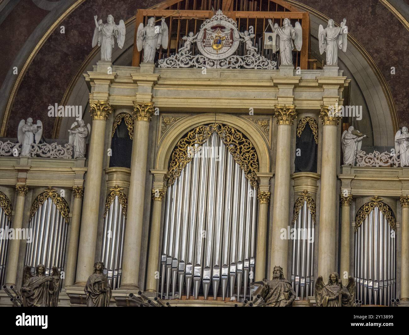 Magnificently decorated organ with angel figures and golden details in ...