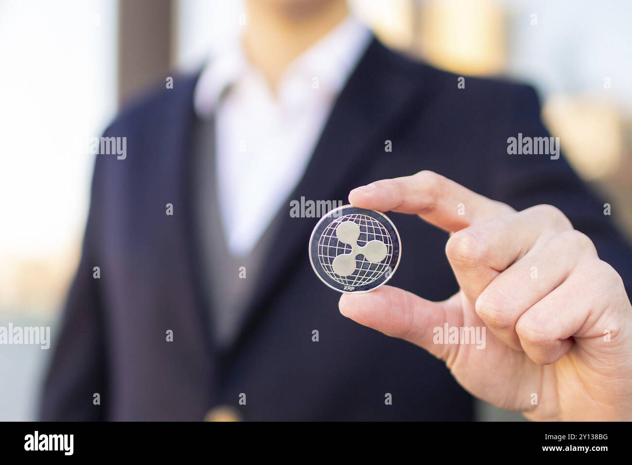 Ripple cryptocurrency coin in a young businessman hand. Disruptive ...