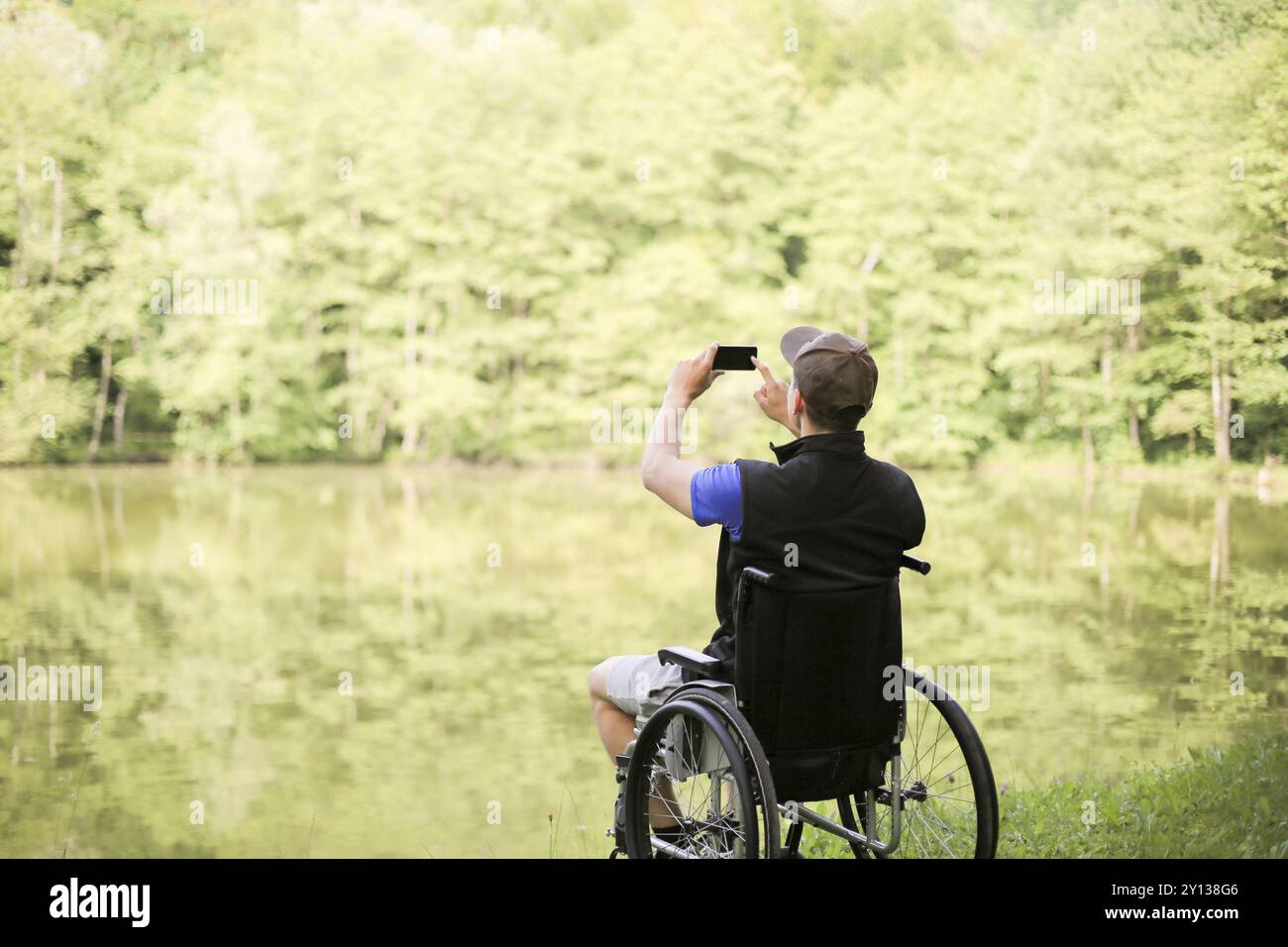 Happy and young disabled or handicapped man sitting on a wheelchair in ...