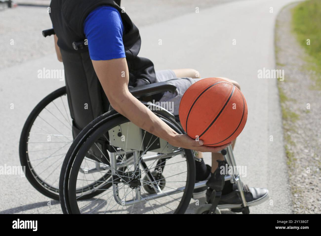 Disabled young basketball player on a wheelchair holding ball and ...