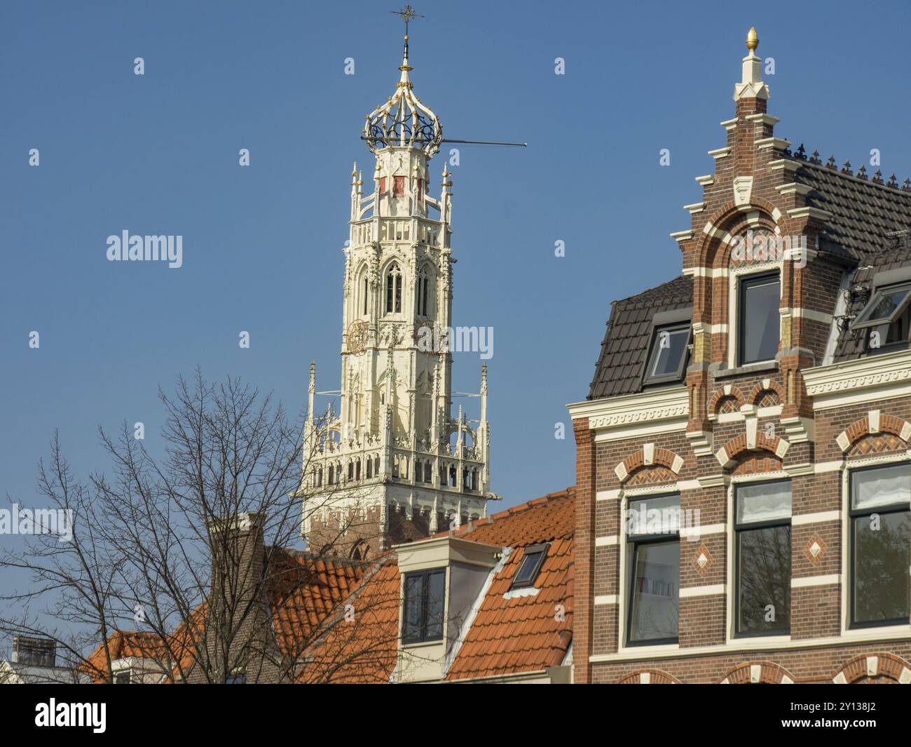 Imposing church tower and historic buildings with red roofs under a ...
