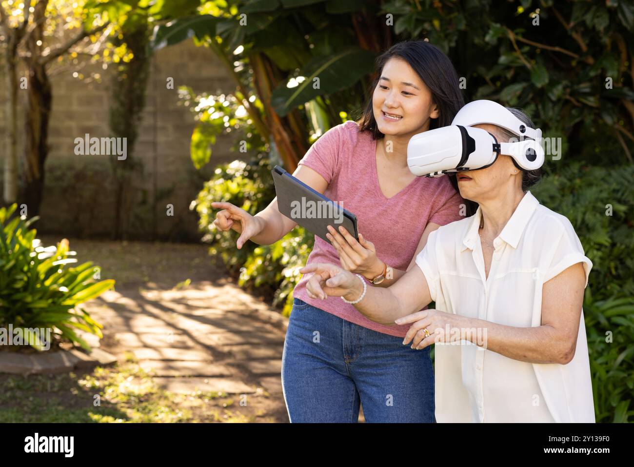 Using VR headset, asian grandmother exploring virtual reality with ...