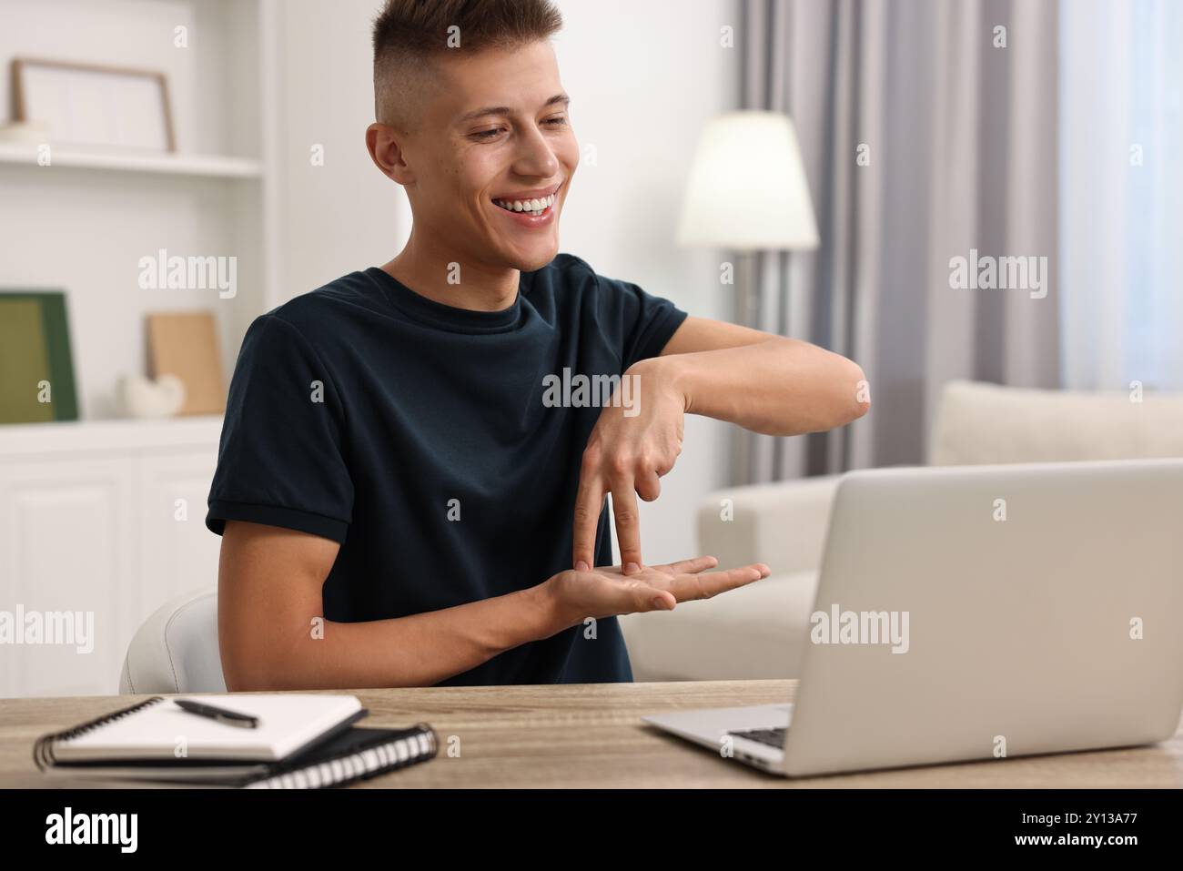 Young man using sign language during video call indoors Stock Photo - Alamy
