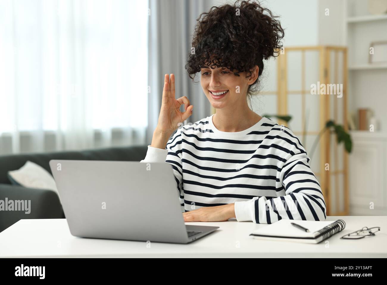 Young woman using sign language for communication during video call at ...