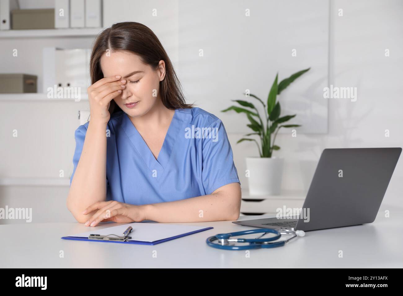 Tired young nurse at workplace in hospital Stock Photo - Alamy