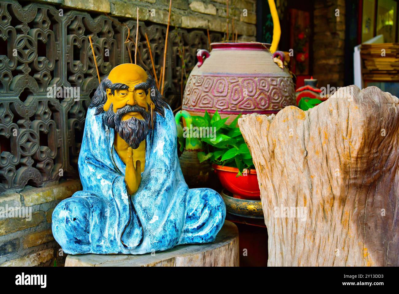 Clay pottery sculpture of a bearded Chinese monk in a blue robe ...