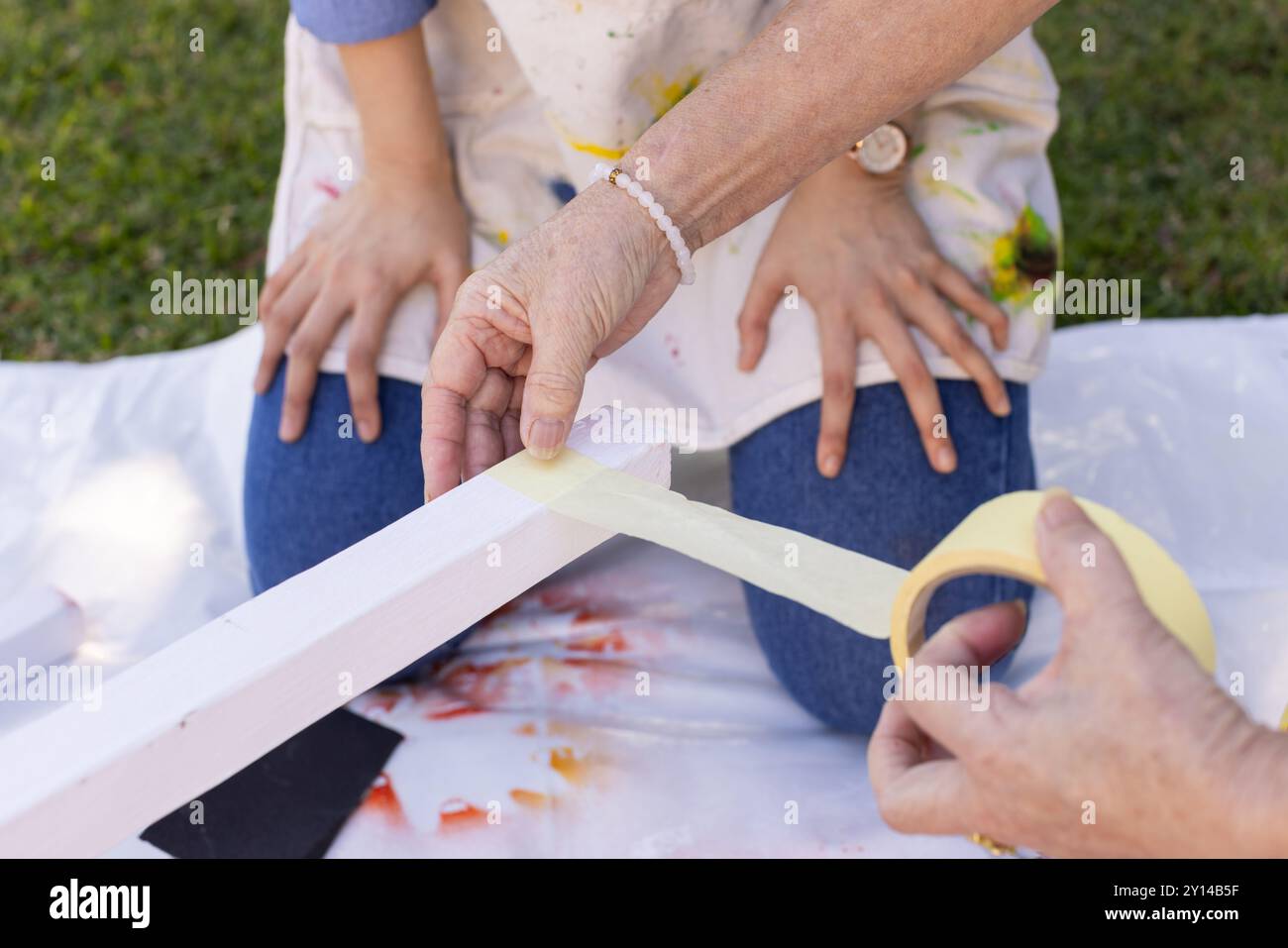 Applying masking tape to wooden plank, person preparing for painting ...