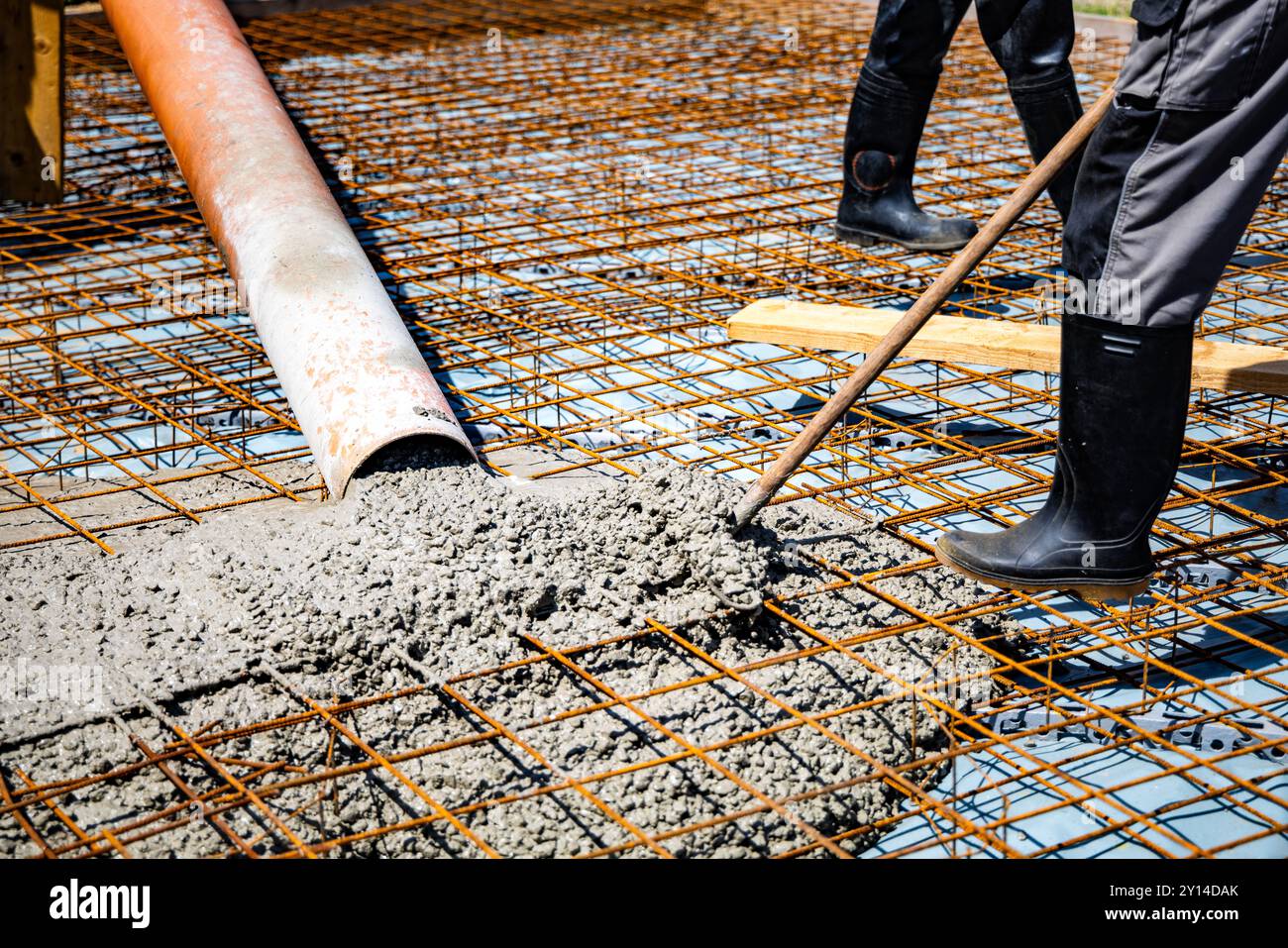 Worker Distributing Concrete onto Rebar Framework for Slab Foundation ...