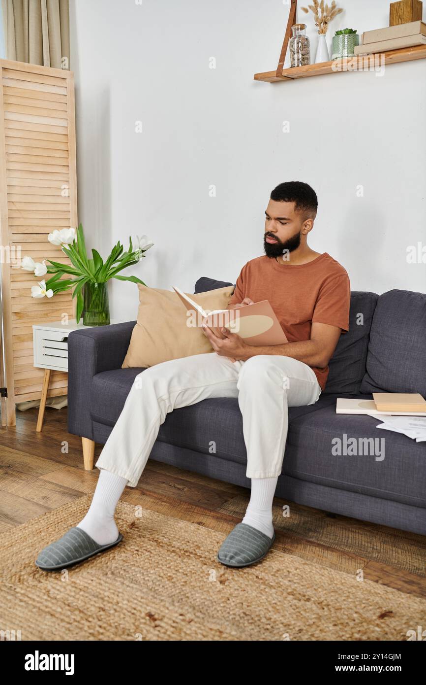 A man enjoys a quiet moment, absorbed in a book at home Stock Photo - Alamy