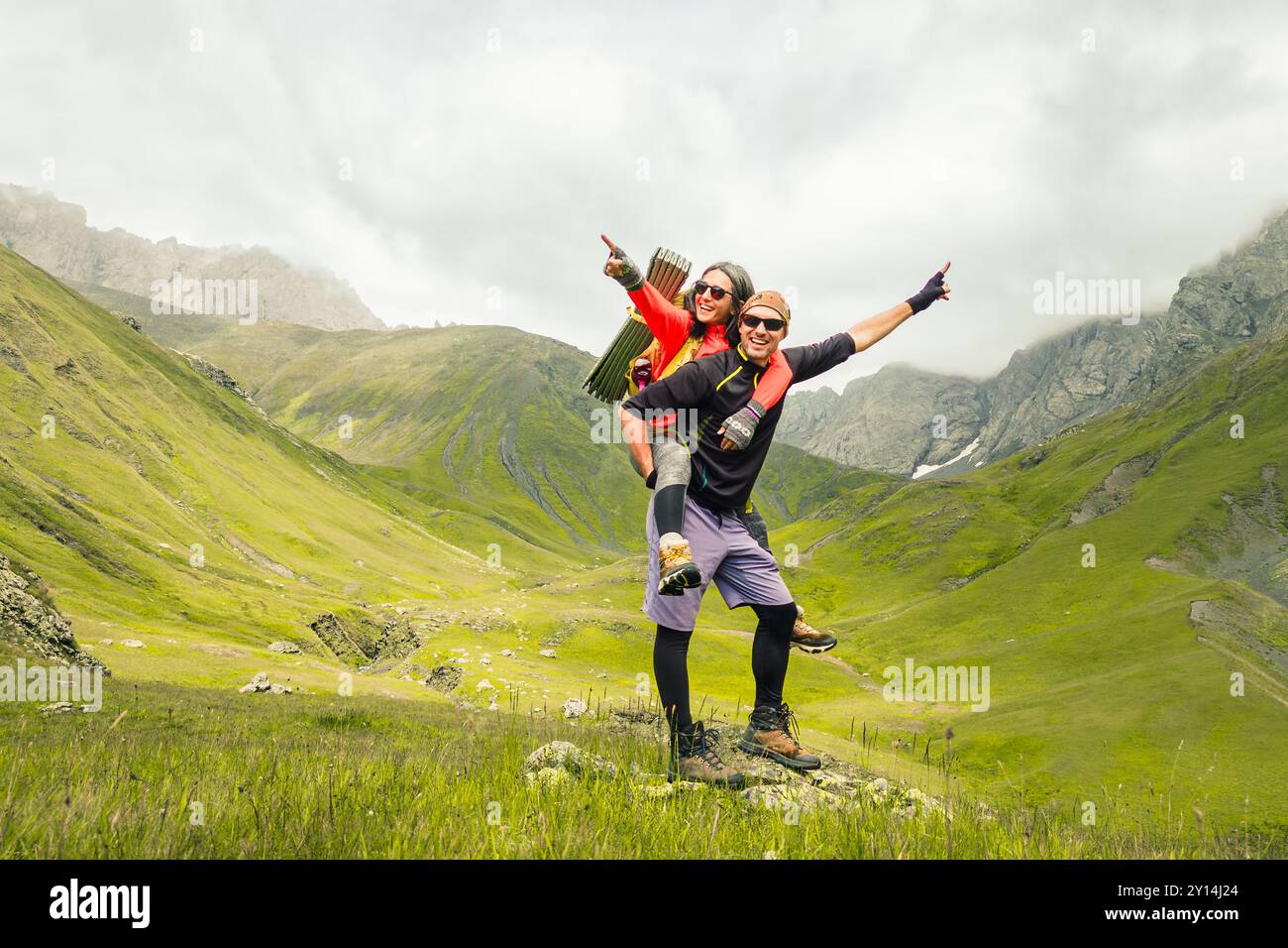Sporty caucasian couple hikers having fun hiking outdoors do piggyback ...