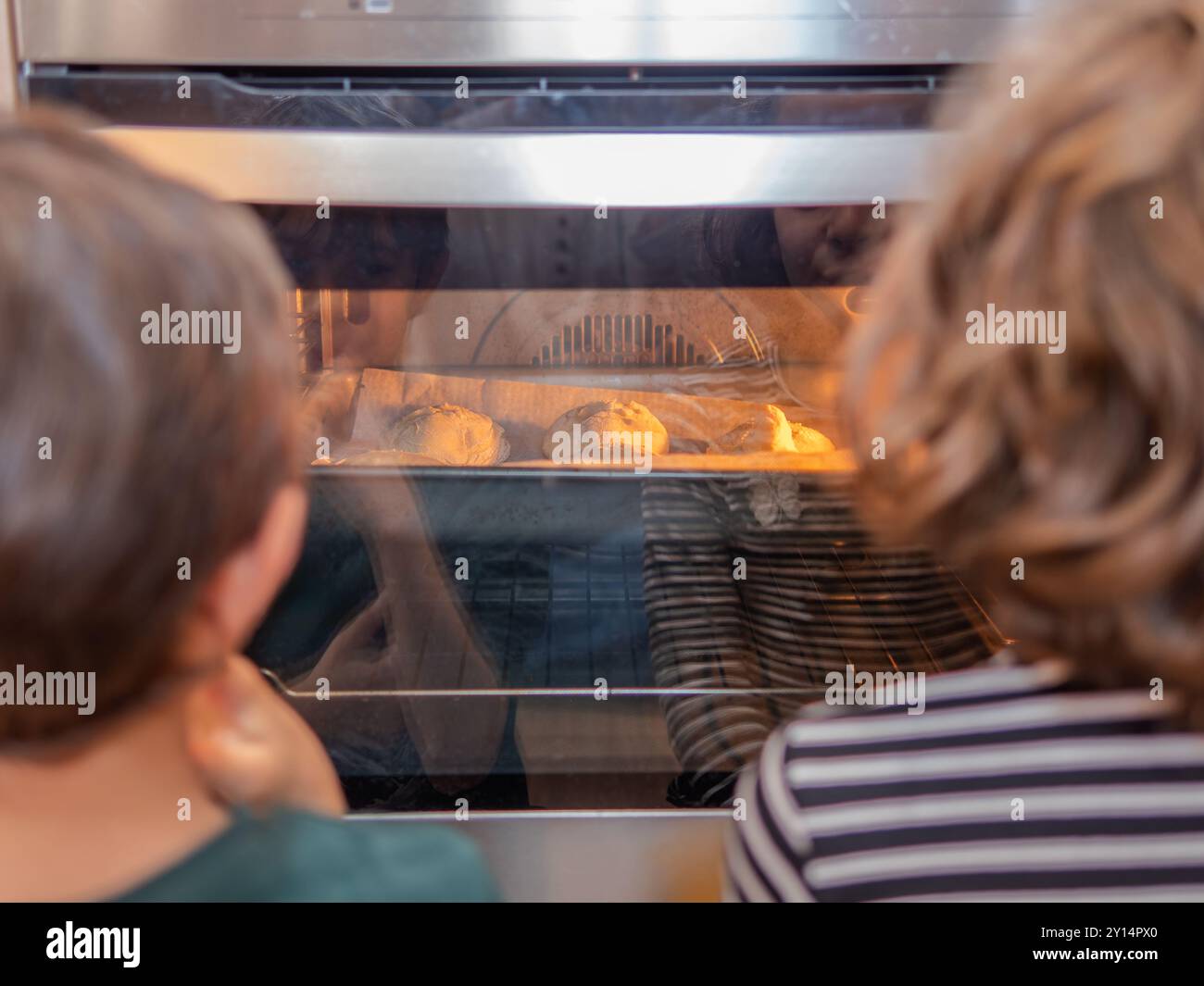 Two children watching baked goods rise in oven Stock Photo - Alamy