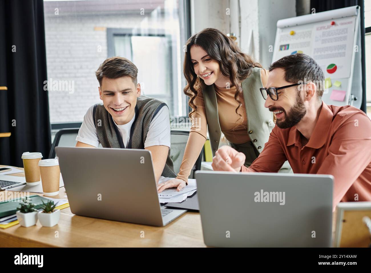 Three colleagues share a light moment at workplace Stock Photo - Alamy