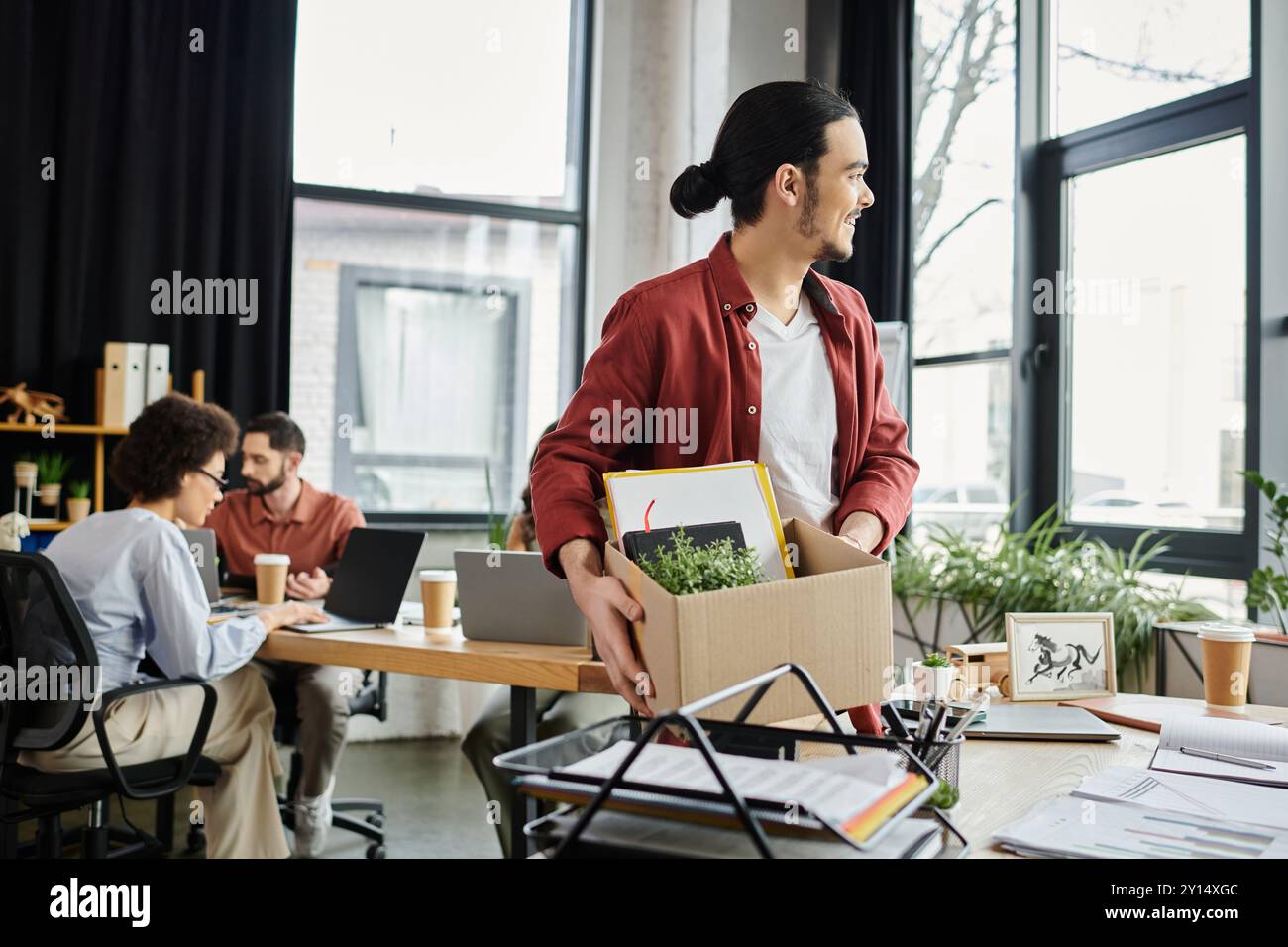 Team members working while one packing items while managing workplace ...