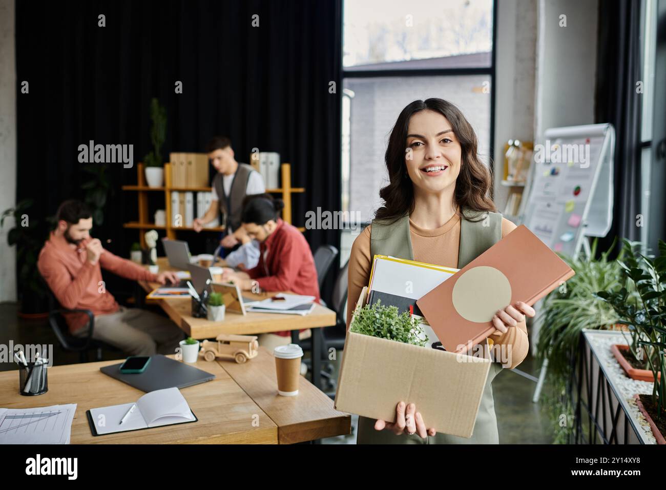 Woman packing belongings during a challenging layoff process ...