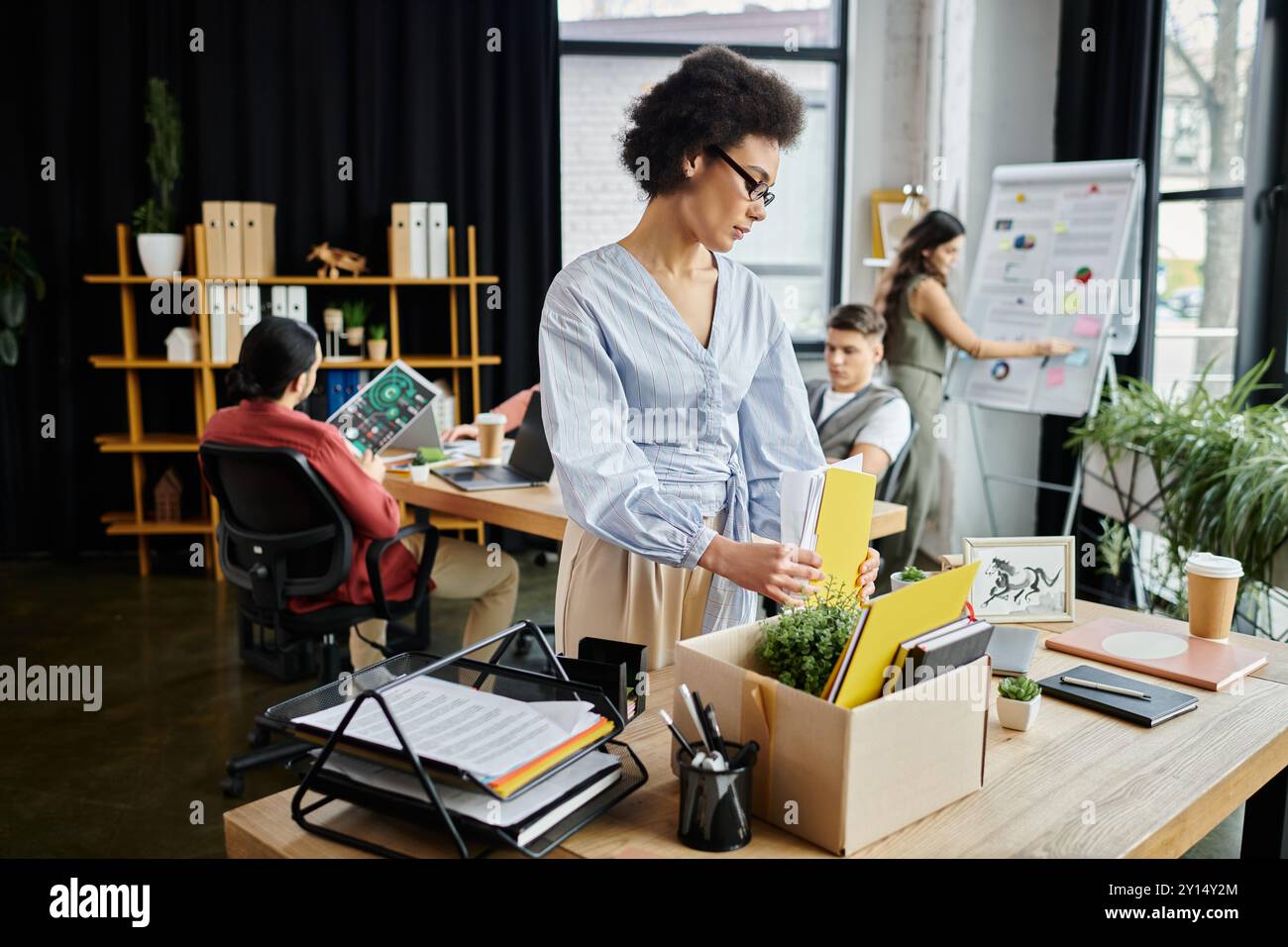 Trendy african american woman packing her items during lay off ...