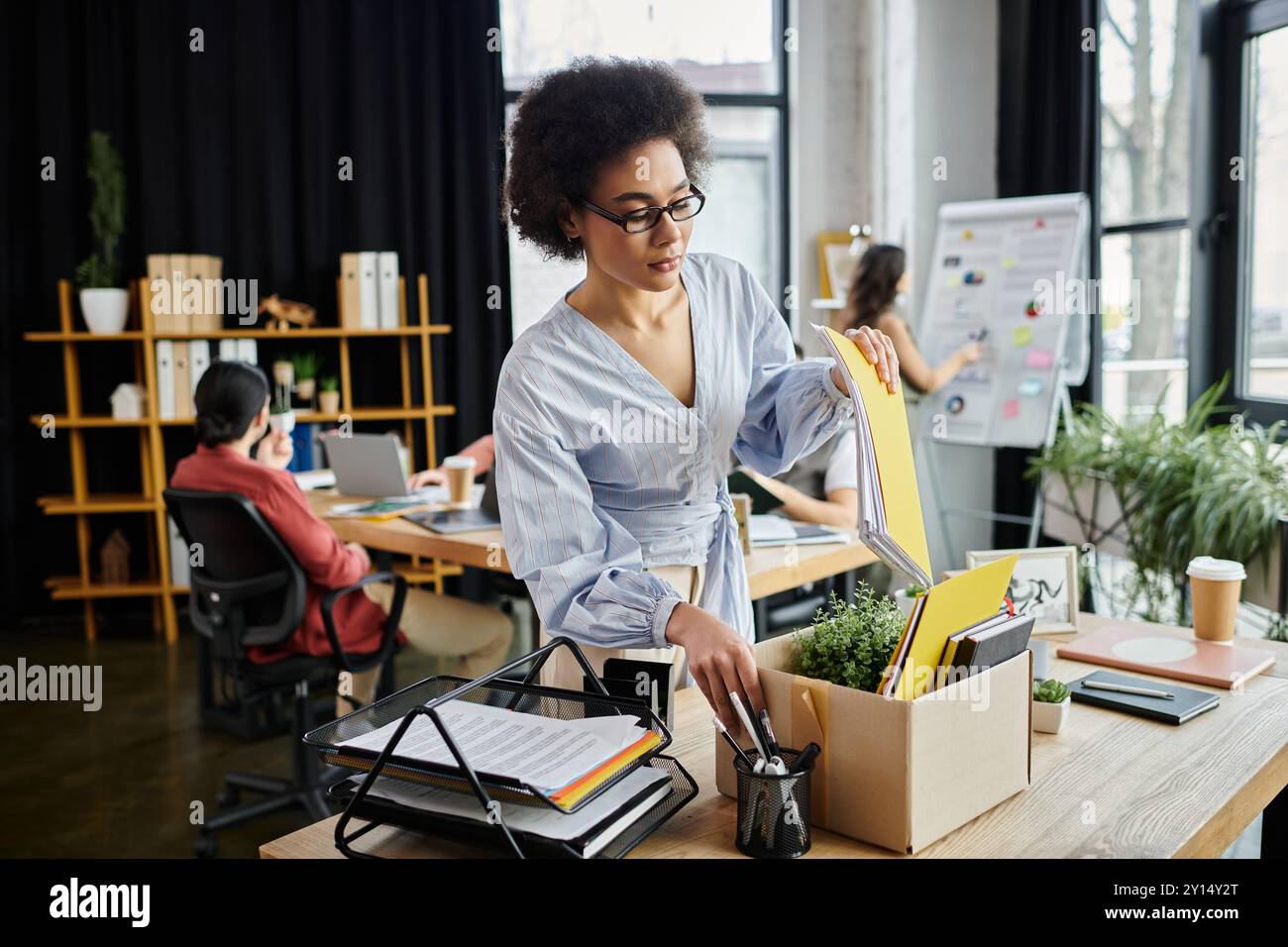 Responsible african american woman packing her items during lay off ...