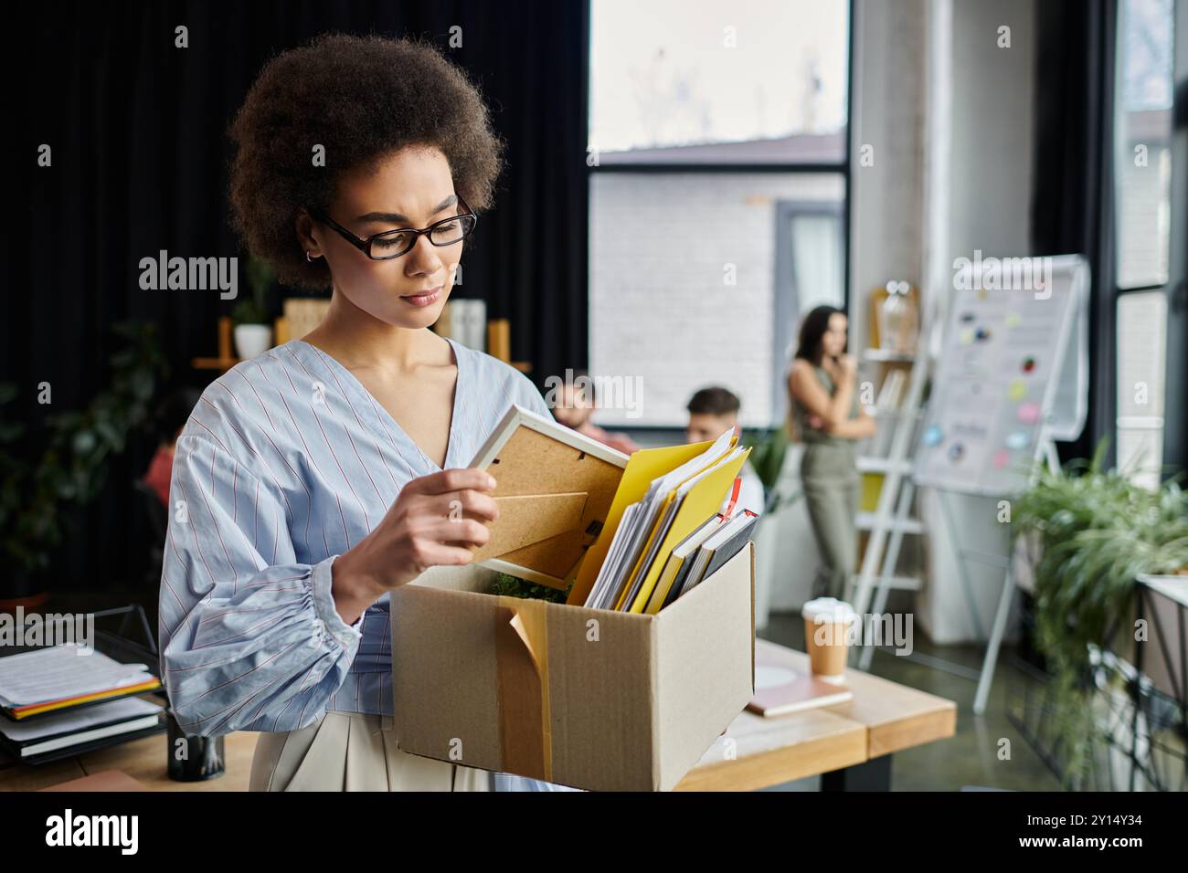 African american woman in elegant attire packing her items during lay ...