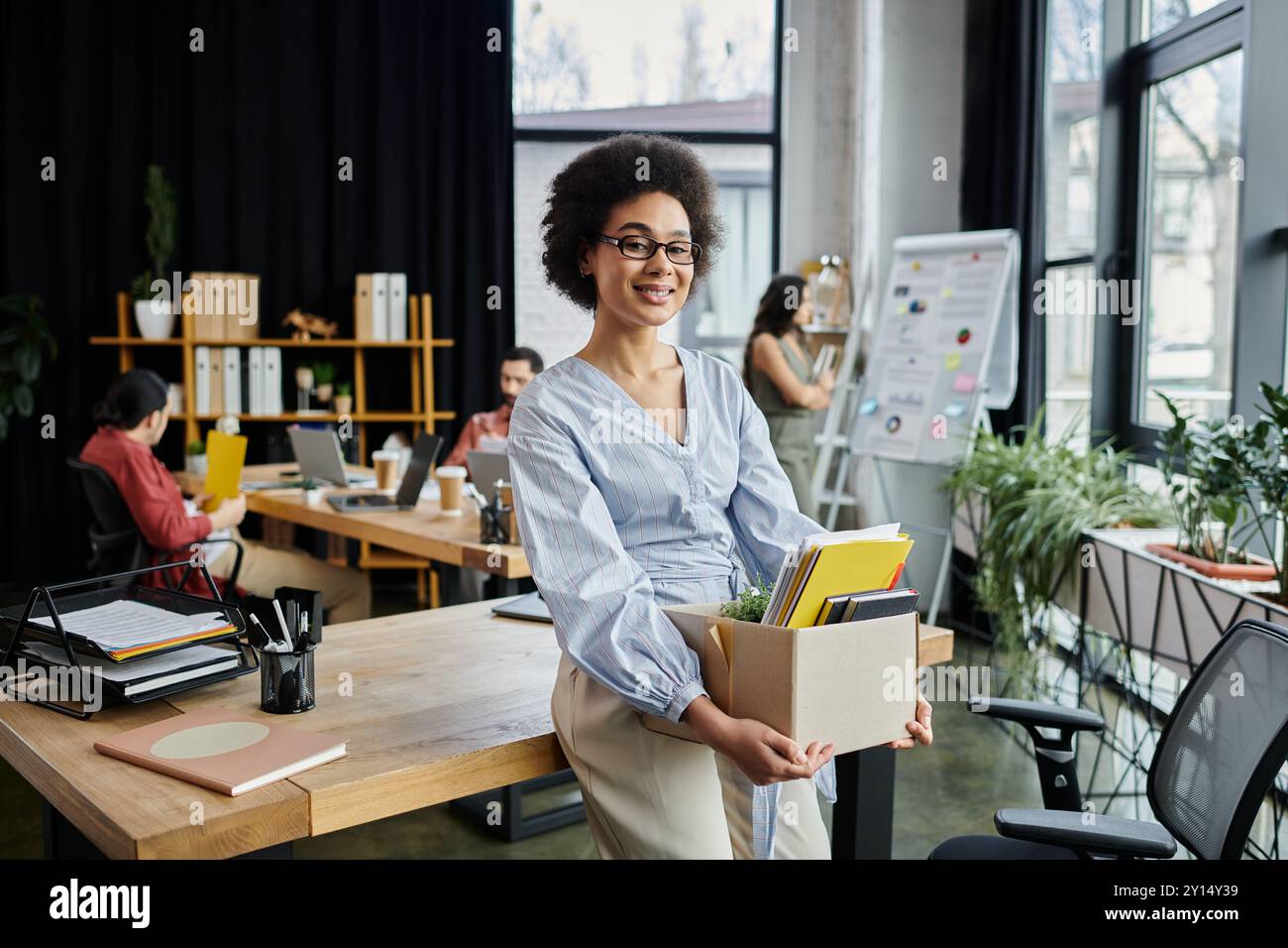 Positive african american woman packing her items during lay off ...