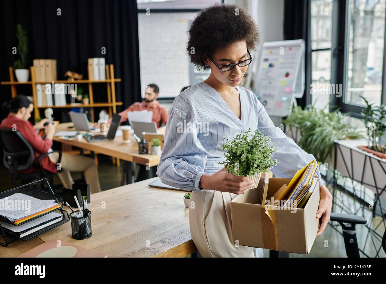 Good looking african american woman packing her items during lay off ...