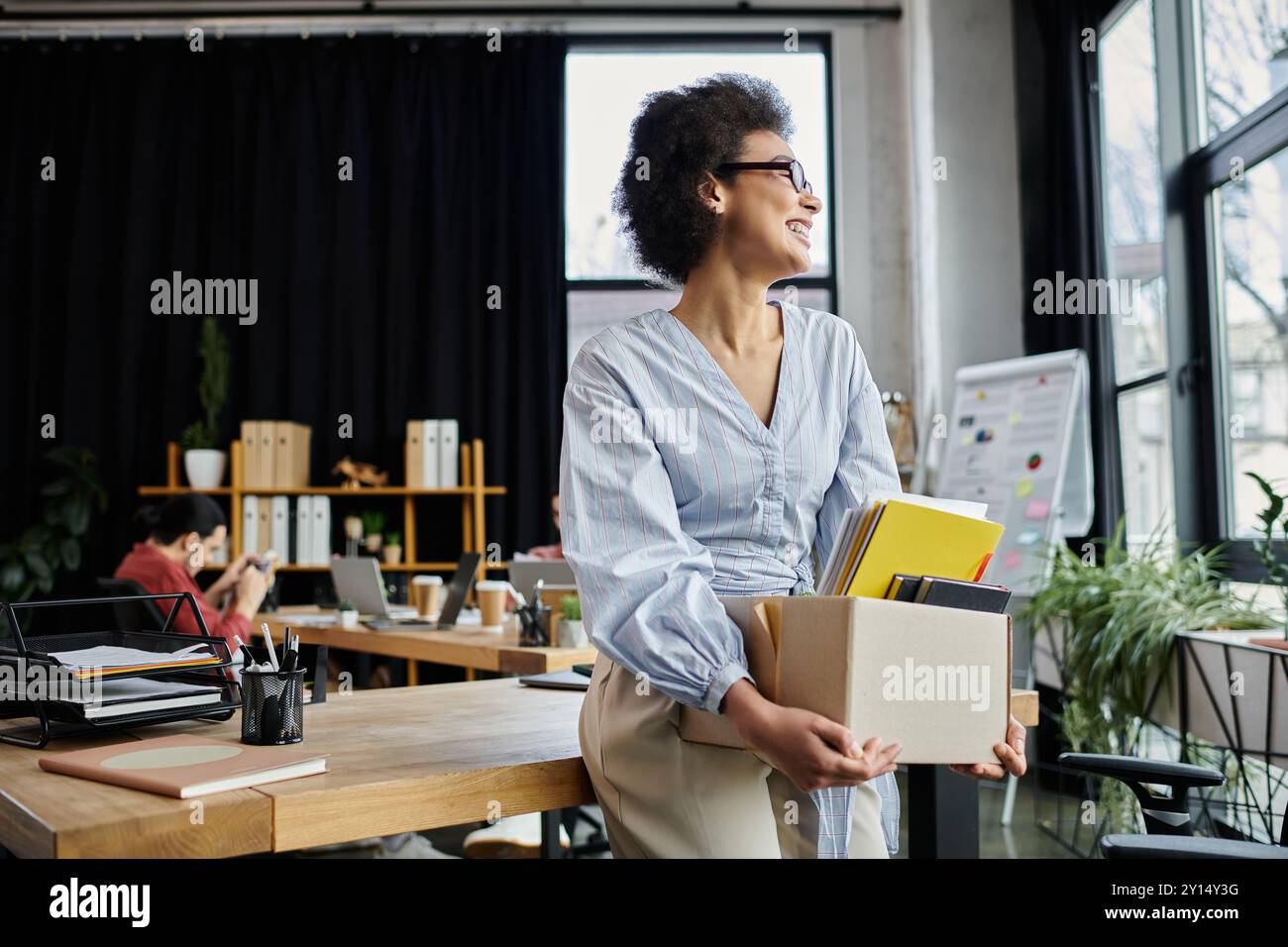 Attractive african american woman packing her items during lay off ...