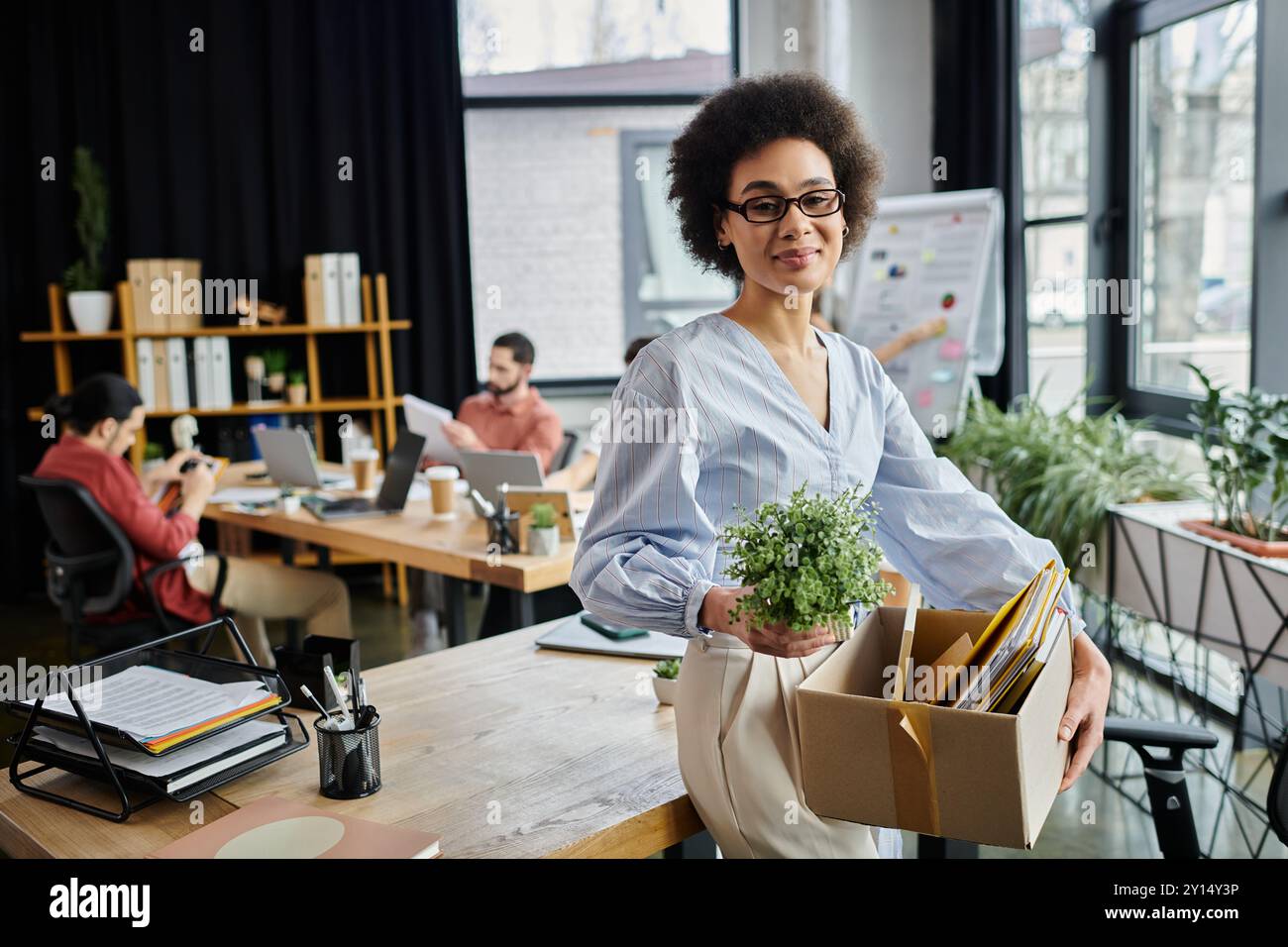 Cheerful african american woman packing her items during lay off ...